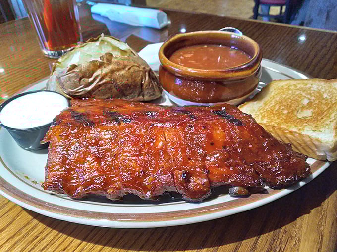 These ribs don't just fall off the bone—they practically leap onto your fork, glistening with sauce that's worth every napkin you'll need.