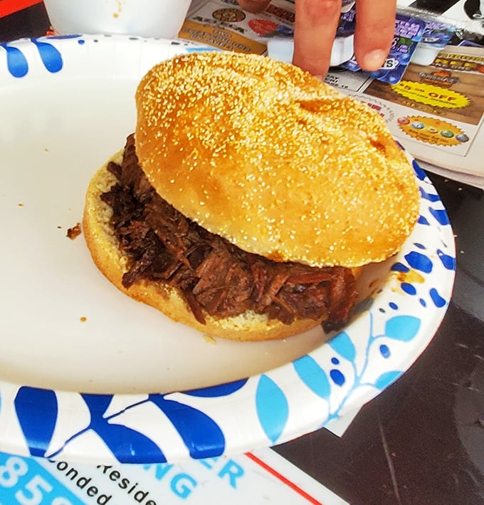 This pulled pork sandwich isn't just a meal - it's an event. The kind of sandwich that makes you cancel afternoon plans for a nap.