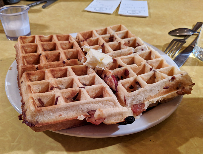 This blueberry waffle isn't just breakfast—it's edible architecture with perfect golden chambers waiting to be filled with melting butter and syrup.