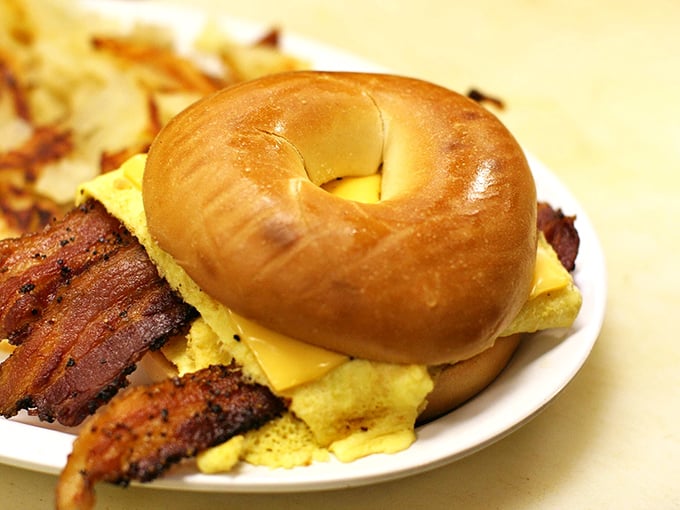 The breakfast sandwich holy trinity: perfectly toasted bagel, eggs that actually taste like eggs, and bacon that would make vegetarians question their life choices.