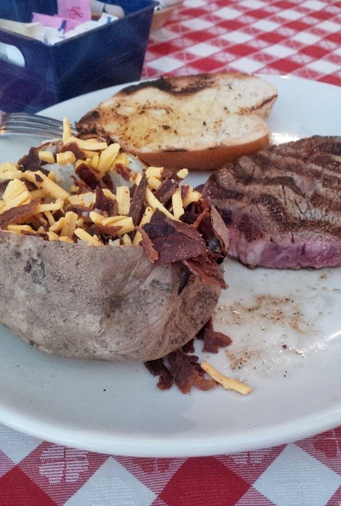 A loaded baked potato and medium-rare steak—the Fred Astaire and Ginger Rogers of comfort food, dancing perfectly together on a white plate.