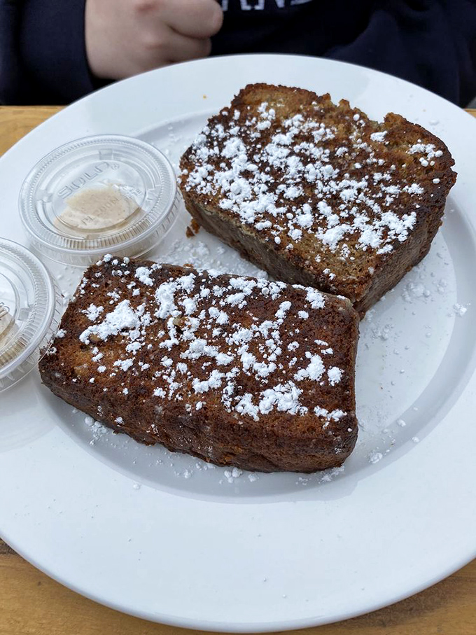 Banana bread dusted with powdered sugar—proof that sometimes the simplest pleasures are the ones worth crossing county lines for.