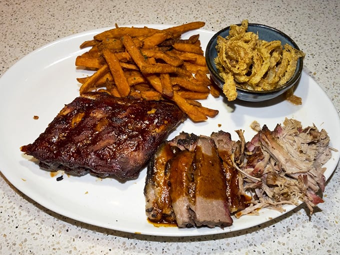 BBQ nirvana on a plate: tender ribs, succulent brisket, and those sweet potato fries that somehow count as a vegetable. Diet starts tomorrow.