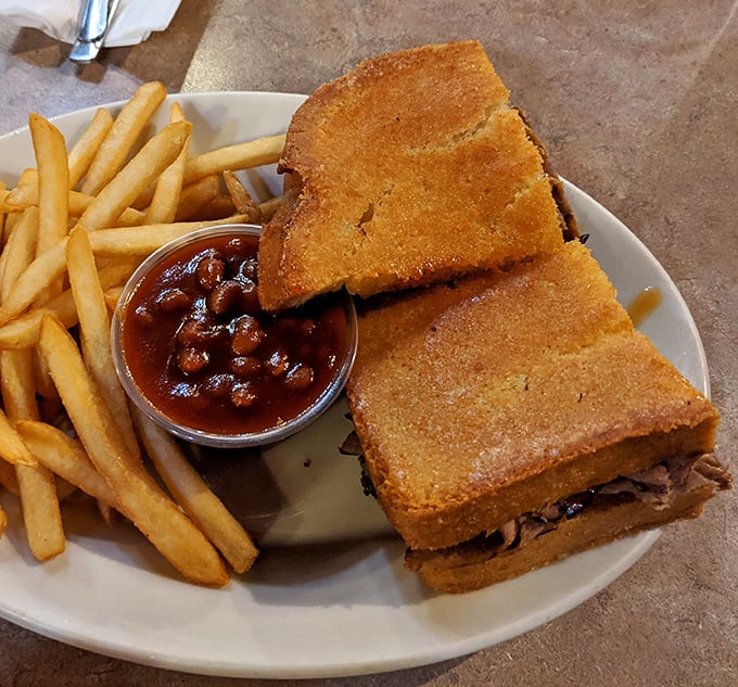 The sandwich that launched a thousand napkins. Golden-crisp garlic toast barely containing a generous heap of smoky meat—architecture that would make Frank Gehry proud.