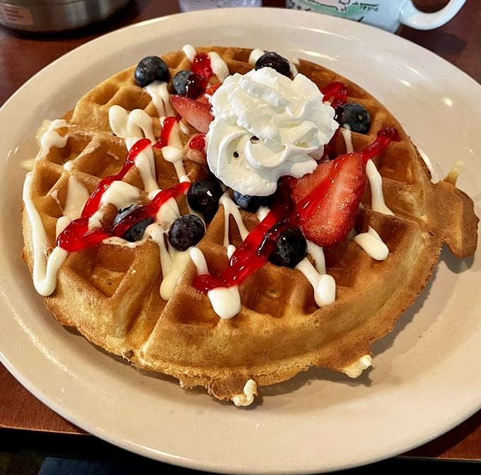 This Belgian waffle doesn't just have toppings—it's wearing a crown of berries, cream, and syrup fit for breakfast royalty.