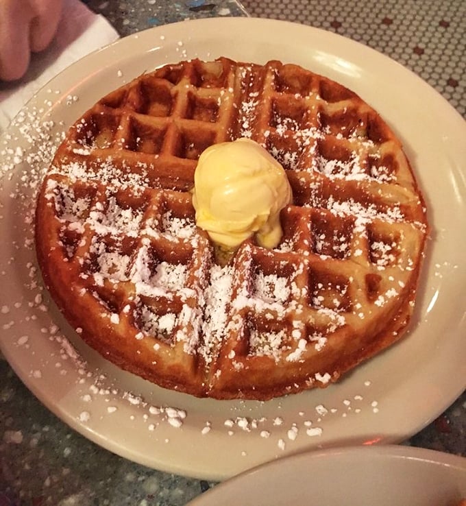 The Belgian waffle arrives like royalty, golden-crowned with butter slowly melting into those perfect squares—a breakfast that demands to be savored.