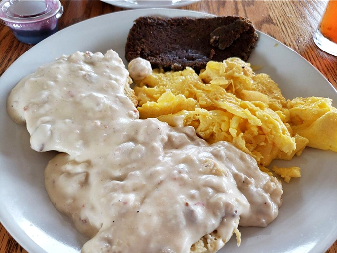 Biscuits drowning happily in creamy sausage gravy alongside golden scrambled eggs—Southern comfort that doesn't judge you for wanting seconds.
