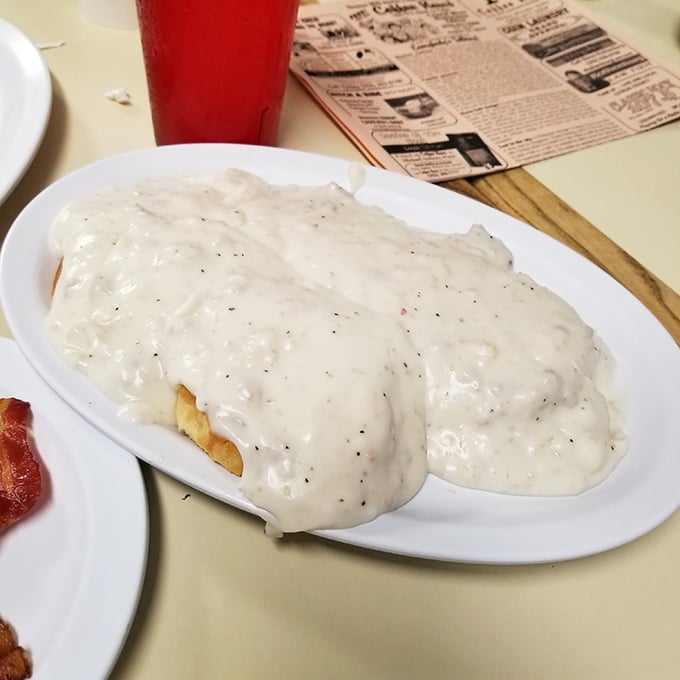 Biscuits swimming in creamy pepper-flecked gravy—a Southern baptism that transforms ordinary mornings into memorable ones. Resistance is futile.