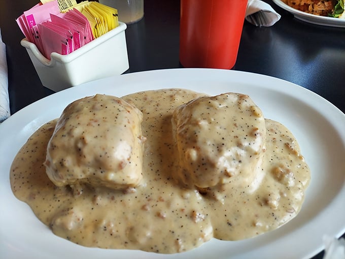 The legendary biscuits and gravy – two pillowy islands floating in a sea of peppery sausage gravy that would make your grandmother simultaneously proud and jealous.