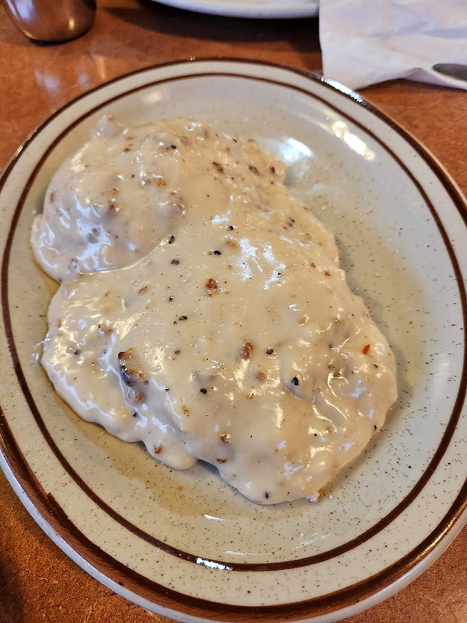 Country gravy cascading over fresh-made biscuits—a Southern hug on a plate that makes you understand why some food memories last forever.