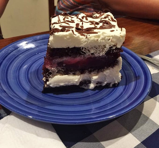 The Black Forest cake arrives like a celebrity—layers of chocolate, cream, and cherries performing a perfect harmony that would make the Black Forest itself proud. 