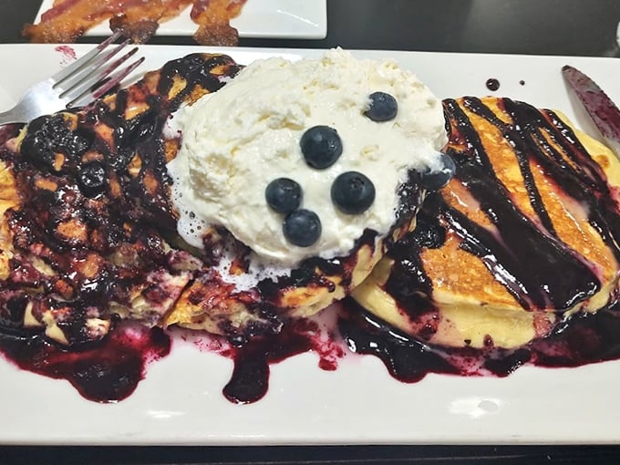 These blueberry pancakes don't just look good—they're practically auditioning for a breakfast hall of fame with that perfect whipped cream crown.