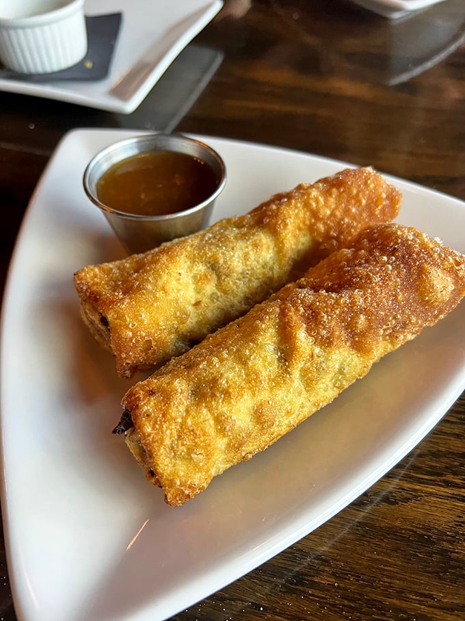 Egg rolls reimagined as vessels of pure indulgence—crispy wrappers giving way to savory fillings with a side of dipping sauce that makes you question why you'd ever order them anywhere else.