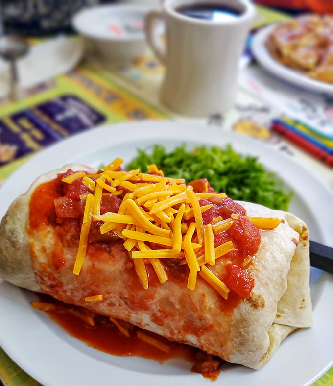 The breakfast burrito – where morning ingredients have a fiesta wrapped in a tortilla blanket, topped with a cheese confetti celebration.