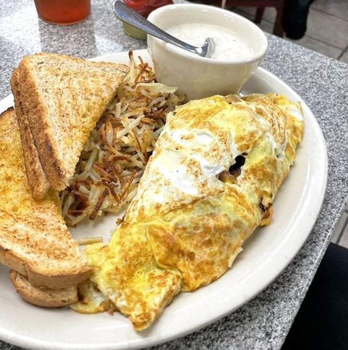 A perfect omelet, crispy hash browns, and toast—the breakfast trinity that proves morning meals aren't just for mornings.