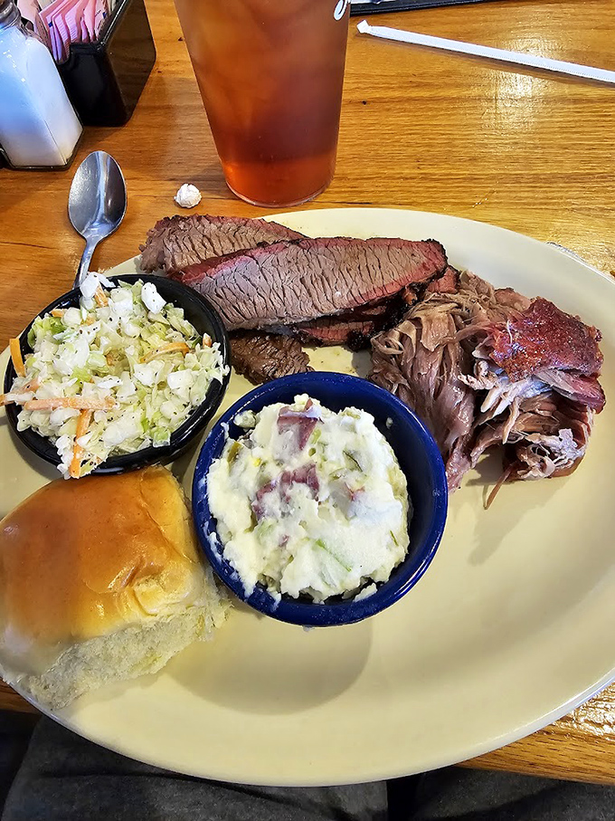 Barbecue trinity: perfectly sliced brisket, pulled pork with bark, and sides that don't know they're supposed to be supporting actors.