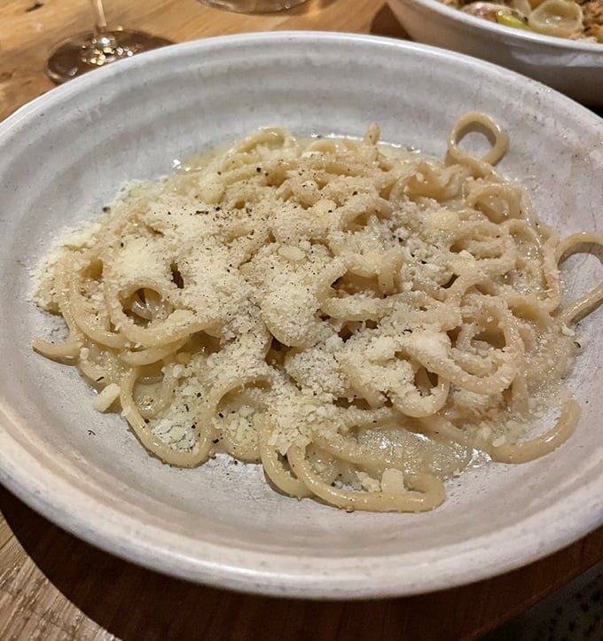 Bucatini cacio e pepe – where simplicity meets genius in a tangle of perfectly al dente pasta dusted with cheese.