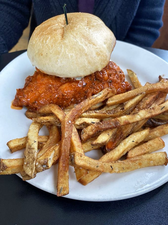 This isn't just a buffalo chicken sandwich—it's a flavor grenade with a bun for a pin. Those fries look like they've been to finishing school.
