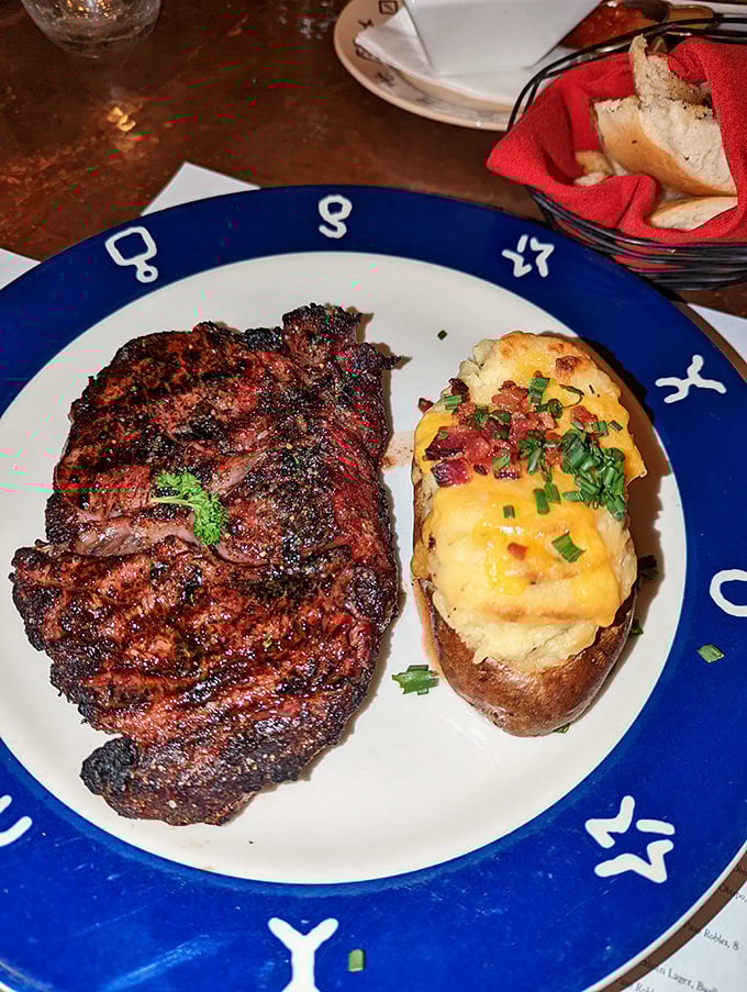 The Bullseye Steak arrives like a carnivore's dream—charred exterior, rosy interior, and a loaded potato that's dressed better than most people at the mall.