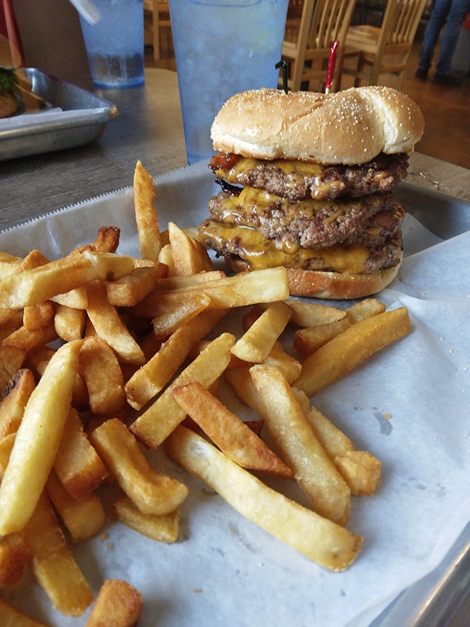 Meet the legendary "Fat Boy" burger in all its towering glory. Those golden fries aren't just a side dish—they're moral support for your impending food coma.
