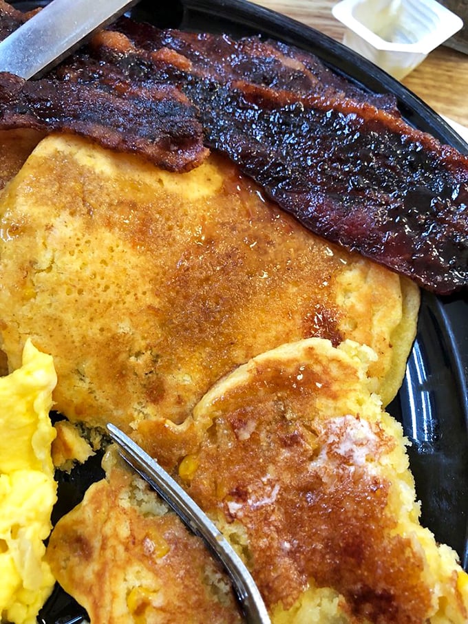 Golden, fluffy pancakes topped with fresh bananas and crispy bacon. Breakfast architecture at its finest—the Guggenheim of morning meals.
