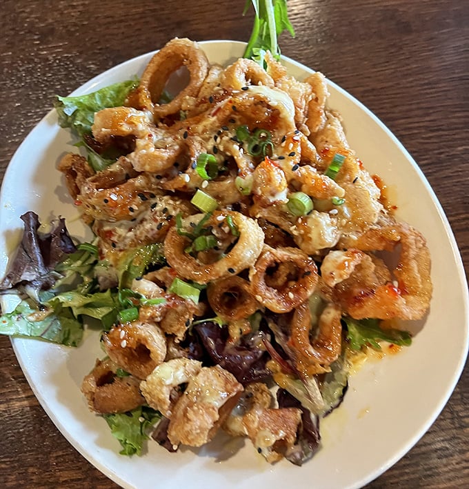 Calamari that doesn't know it's in Ohio – crispy, tender rings nestled on greens with a sauce that makes you forget you're hundreds of miles from any ocean.
