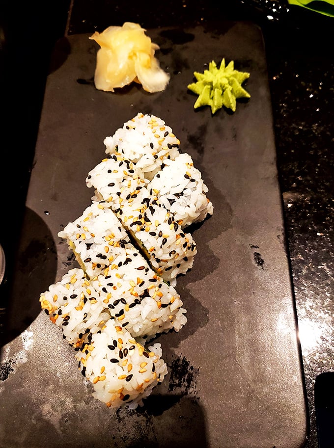 These perfectly formed California rolls aren't just appetizers; they're edible art sprinkled with sesame seeds like tiny flavor confetti.