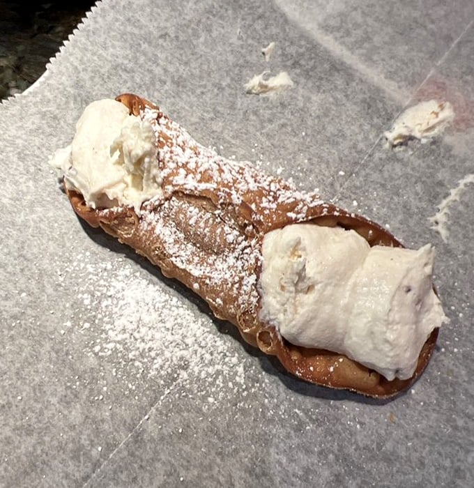 This cannoli isn't just dessert—it's the exclamation point at the end of a perfect meal. Crisp shell, creamy filling, and a dusting of powdered sugar dreams.
