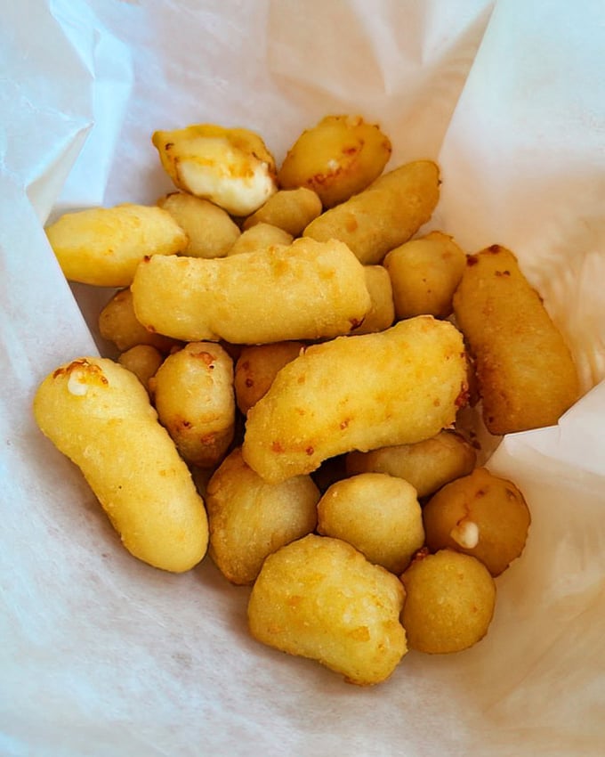 These cheese curds aren't just fried—they're transformed into golden nuggets of joy that make grown adults giggle with delight.
