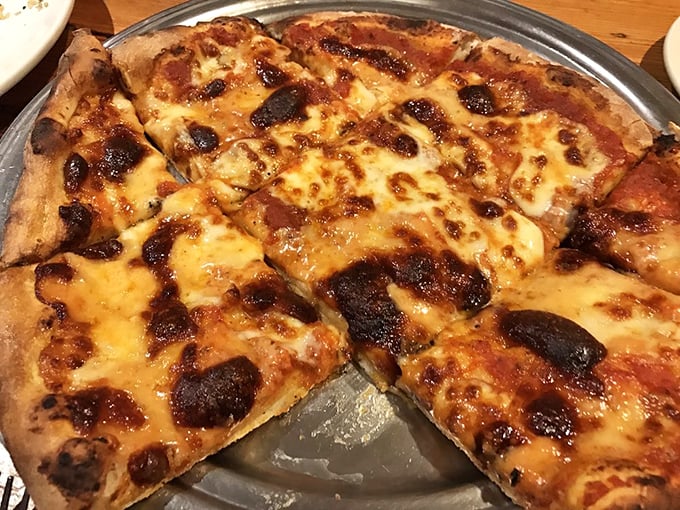 The brick oven pizza emerges with that perfect char—the kind that makes you wonder why you'd eat pizza anywhere else.