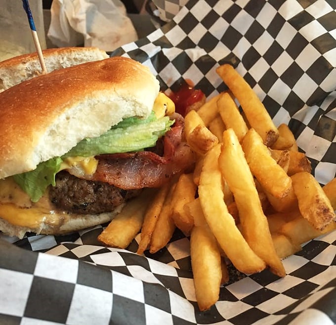 The cheeseburger and fries combo—America's most perfect food pairing since peanut butter met jelly, served on classic checkered paper.