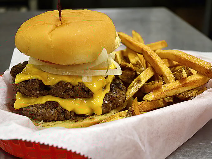 A burger that requires both hands and possibly a nap afterward. Those golden fries aren't just a side—they're co-stars in this delicious production.