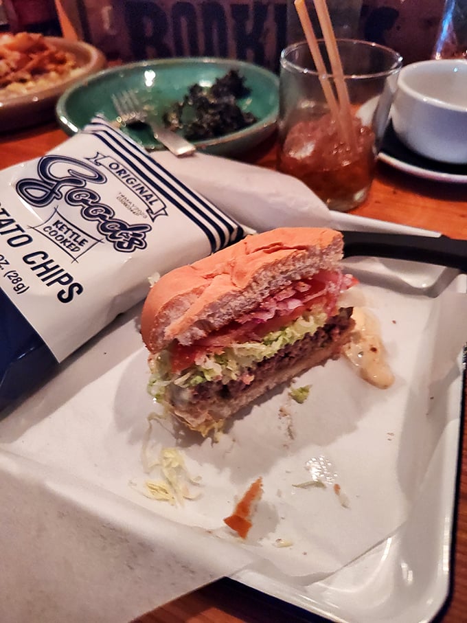 A burger that demands to be photographed before it's devoured – layered with fresh toppings and paired with classic kettle chips for that perfect crunch.
