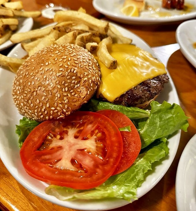 This isn't just a cheeseburger—it's architecture. The perfect stack of beef, cheese, lettuce and tomato on a sesame throne.