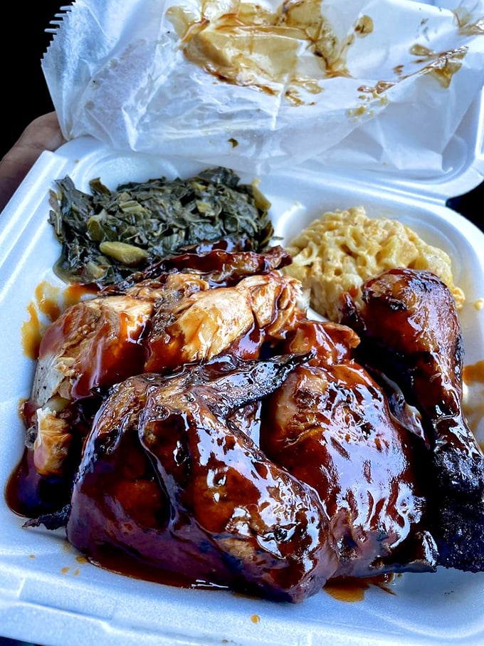 Smoky chicken nestled beside mac and cheese and collard greens – the holy trinity of Southern comfort on styrofoam.