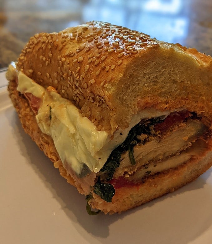 This chicken sandwich on sesame-studded bread isn't just lunch—it's edible architecture with layers of flavor that would make Frank Lloyd Wright jealous.