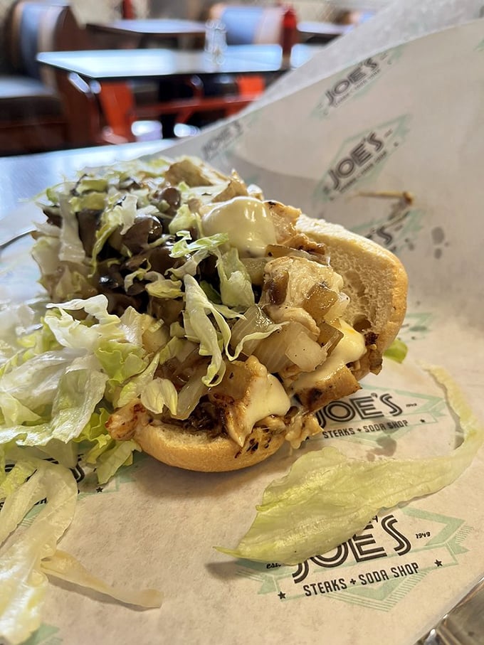 Behold the chicken cheesesteak in all its lettuce-topped glory – proof that sometimes the understudy deserves just as much applause as the headliner.