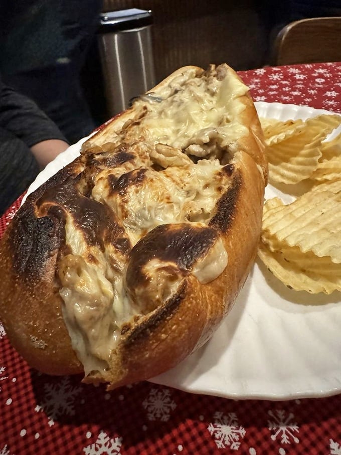 Behold the chicken cheesesteak in its natural habitat—gloriously melty, perfectly toasted, and flanked by ridged potato chips standing at attention. 