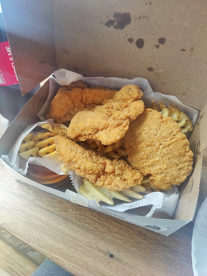 Golden-fried chicken tenders nestled on a bed of fries – comfort food that whispers, "Diet? What diet? We're having a moment here."