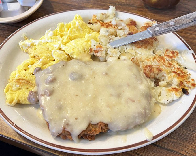 Country-fried steak swimming in gravy – because sometimes your arteries deserve a vacation day.