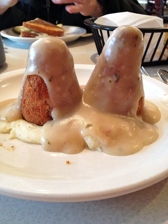 The legendary chicken croquettes stand like twin monuments to comfort food perfection, bathed in gravy that should be classified as a controlled substance.