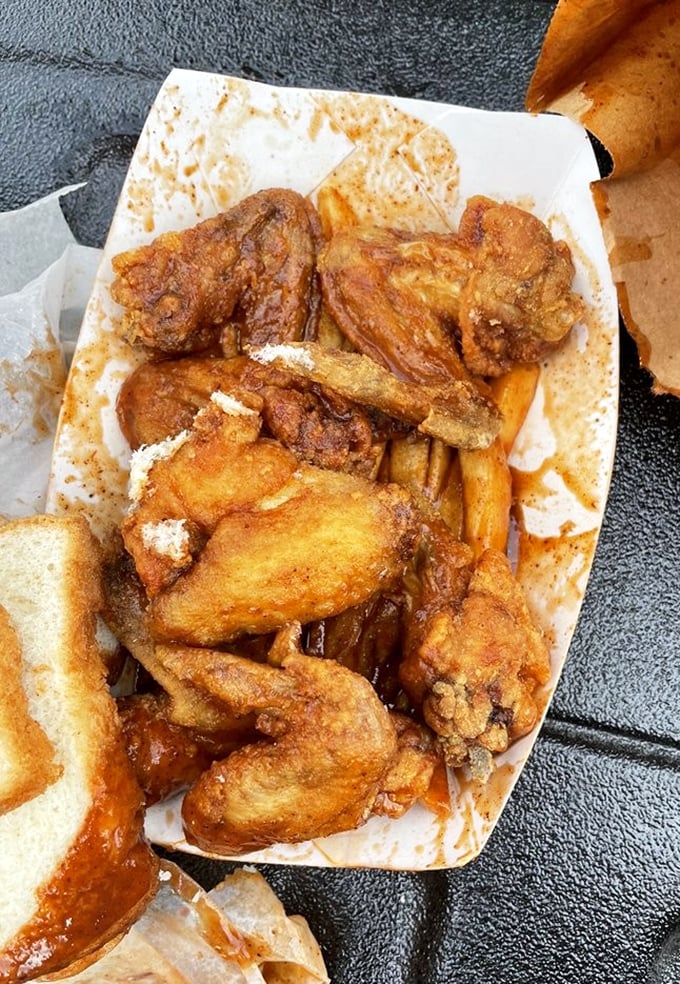 Fried wings nestled among french fries and white bread—the holy trinity of comfort food that makes Monday feel like Saturday.