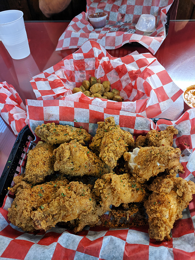 These golden-brown beauties aren't just chicken wings—they're crispy vessels of joy served in classic red-and-white checkered paper boats.