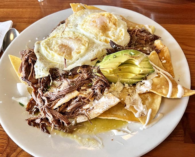 Breakfast reimagined: shredded meat, crispy tortillas, perfectly fried eggs, and avocado—a morning fiesta that makes waking up worthwhile.