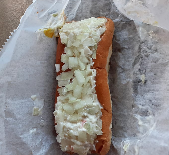 This slaw dog isn't just a meal—it's a Southern handshake in food form, with crisp onions standing at attention atop creamy slaw.