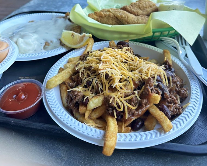 Fries living their best life under a blanket of chili and cheese. This isn't a side dish—it's a commitment to happiness that requires both a fork and napkins.