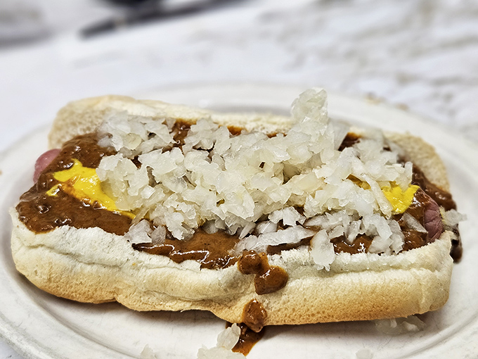 The proper Detroit coney experience includes diced onions that add both crunch and bite. This isn't food photography—it's edible history.