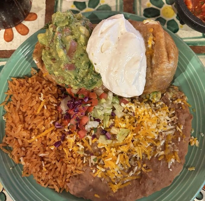 This chimichanga isn't just dinner—it's architecture. A perfectly crisp exterior giving way to tender filling, topped with guacamole that's practically glowing with freshness.