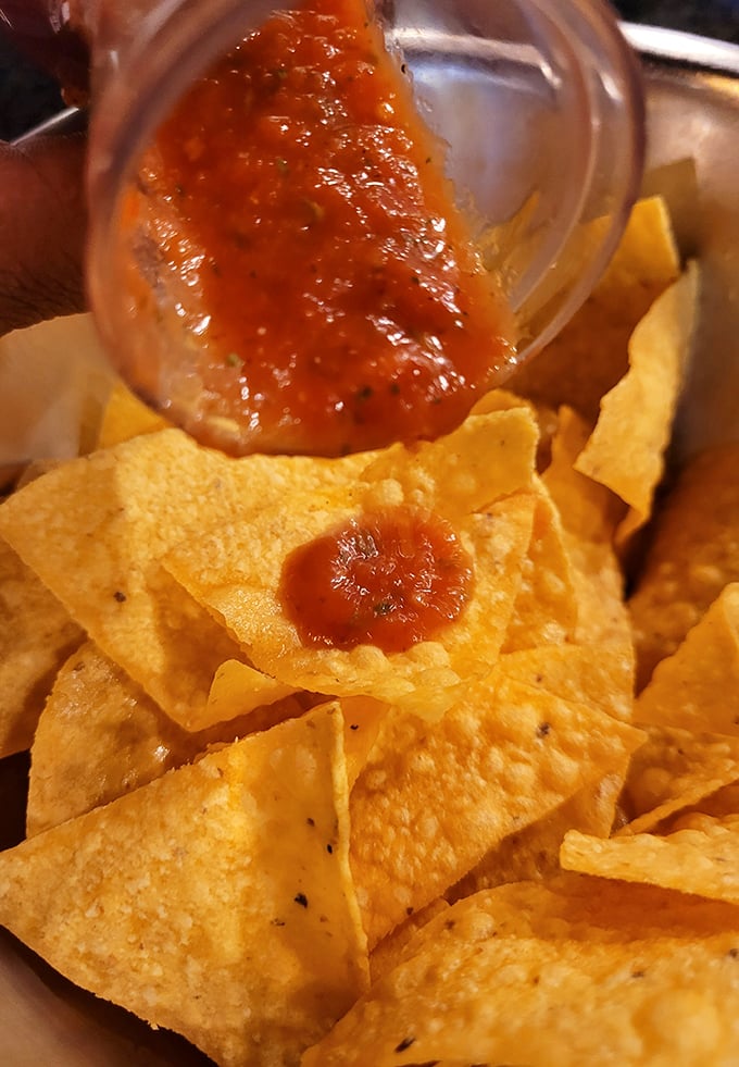 That moment when fresh salsa cascades onto crispy homemade chips—a simple pleasure that somehow makes everything right with the world.