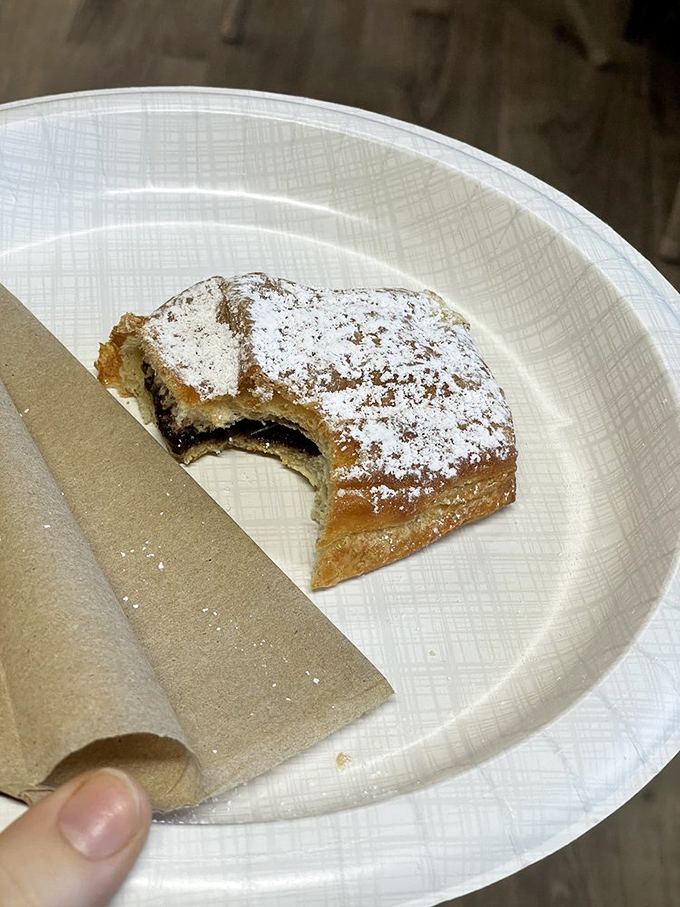 Not all heroes wear capes—some wear layers of pastry and hide dark chocolate treasures within. This powdered sugar-dusted delight demands a moment of silence.